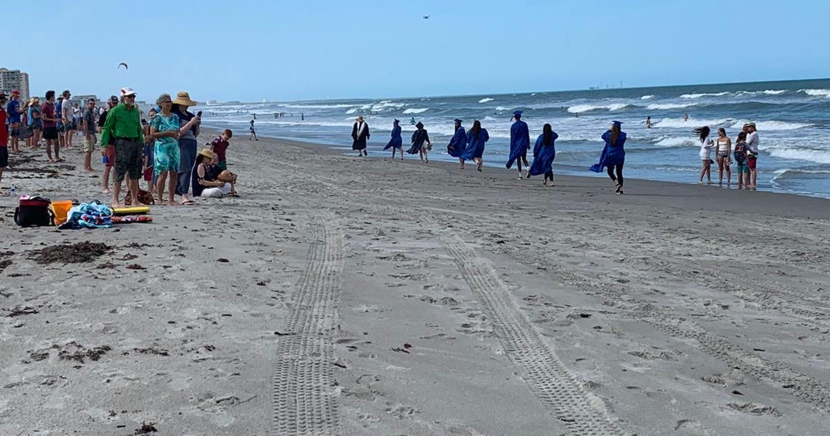 Cocoa Beach seniors walk down the beach in caps and gowns to celebrate ...